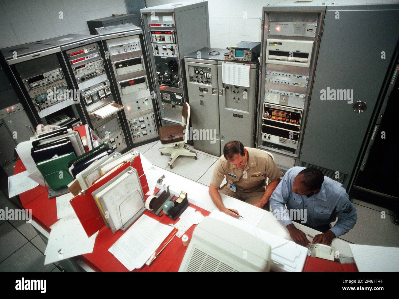 A lieutenant commander and a first class petty officer check over a ...