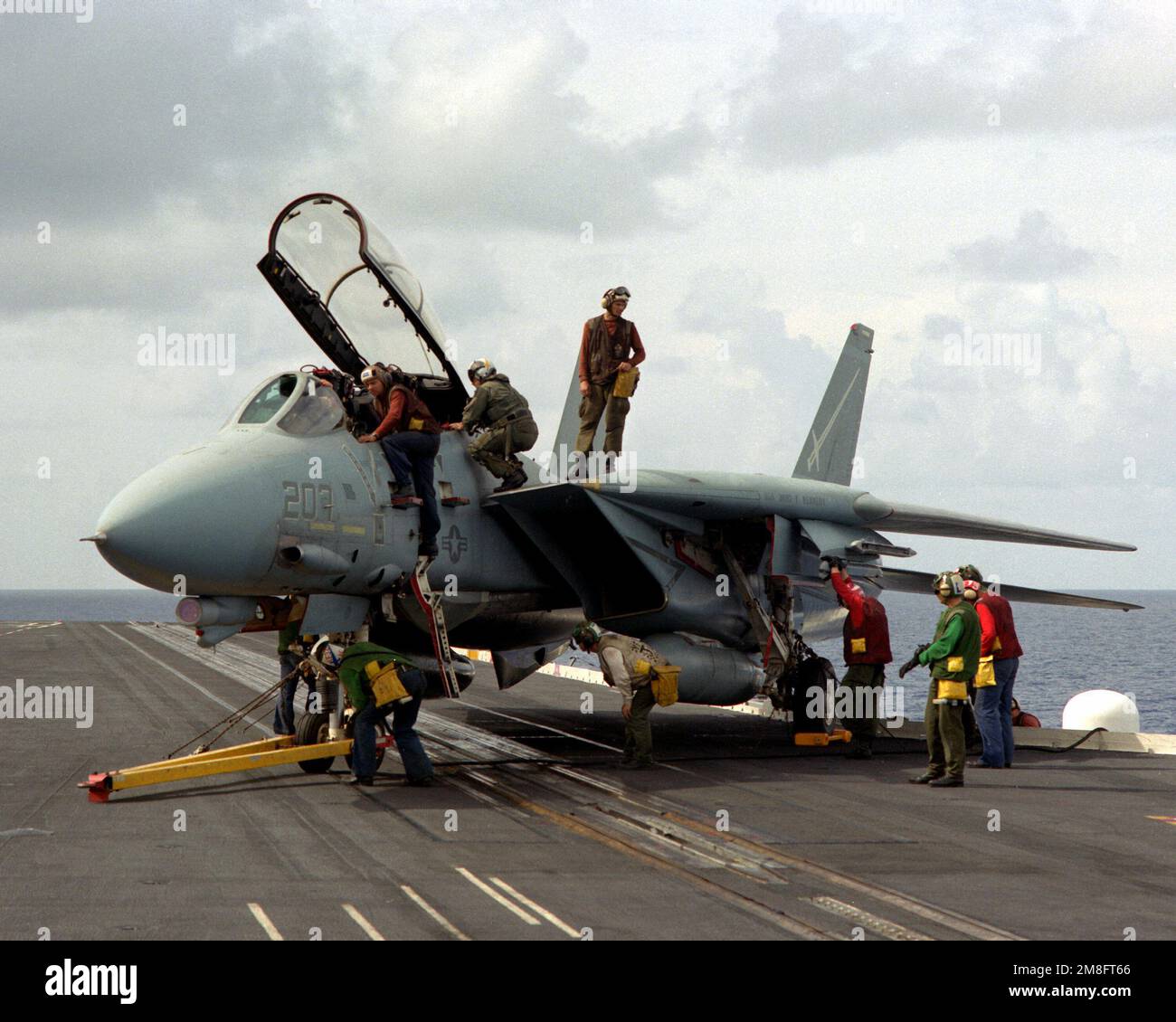 Flight deck crewmen prepare to move a Fighter Squadron 32 (VF-32) F-14 ...