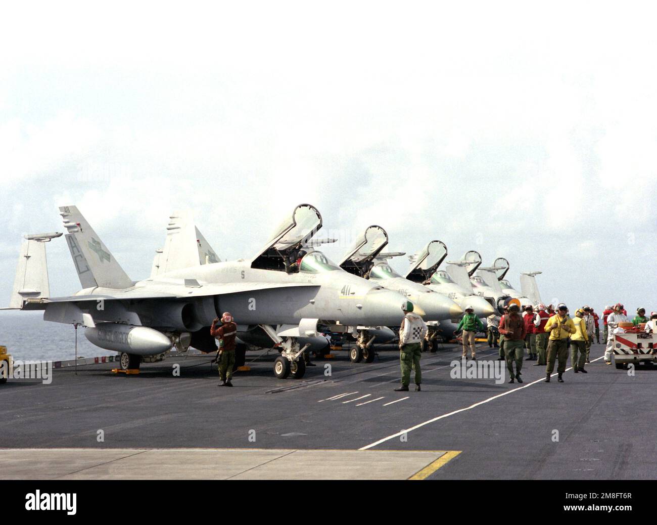 Flight deck crewmen ready Strike Fighter Squadron 105 (VFA-105) F/A-18C ...