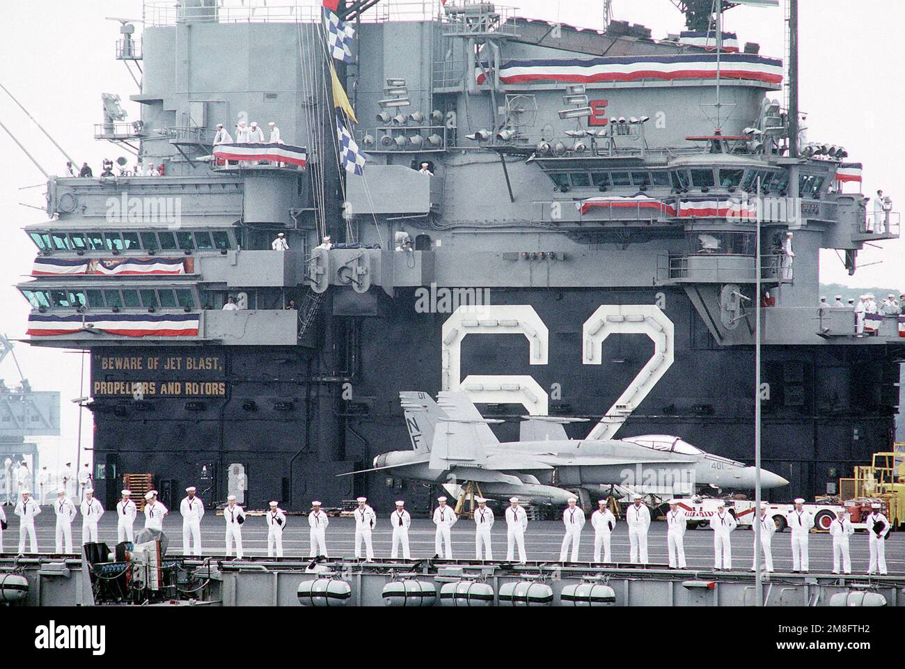 Sailors man the rails near a Strike Fighter Sqaudron 113 (VFA-113) F/A ...