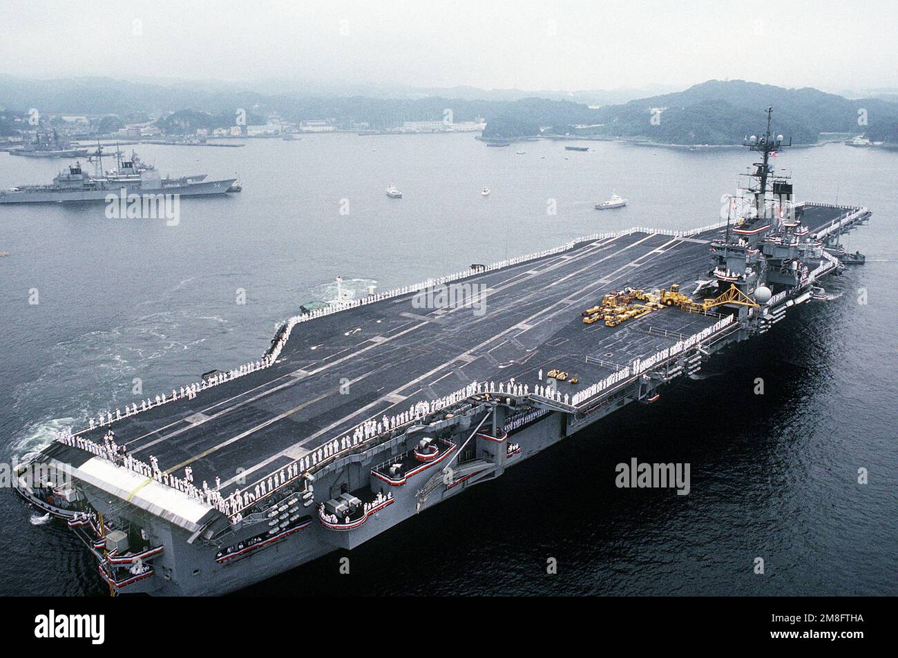 Crew members man the rails aboard the aircraft carrier USS INDEPENDENCE ...