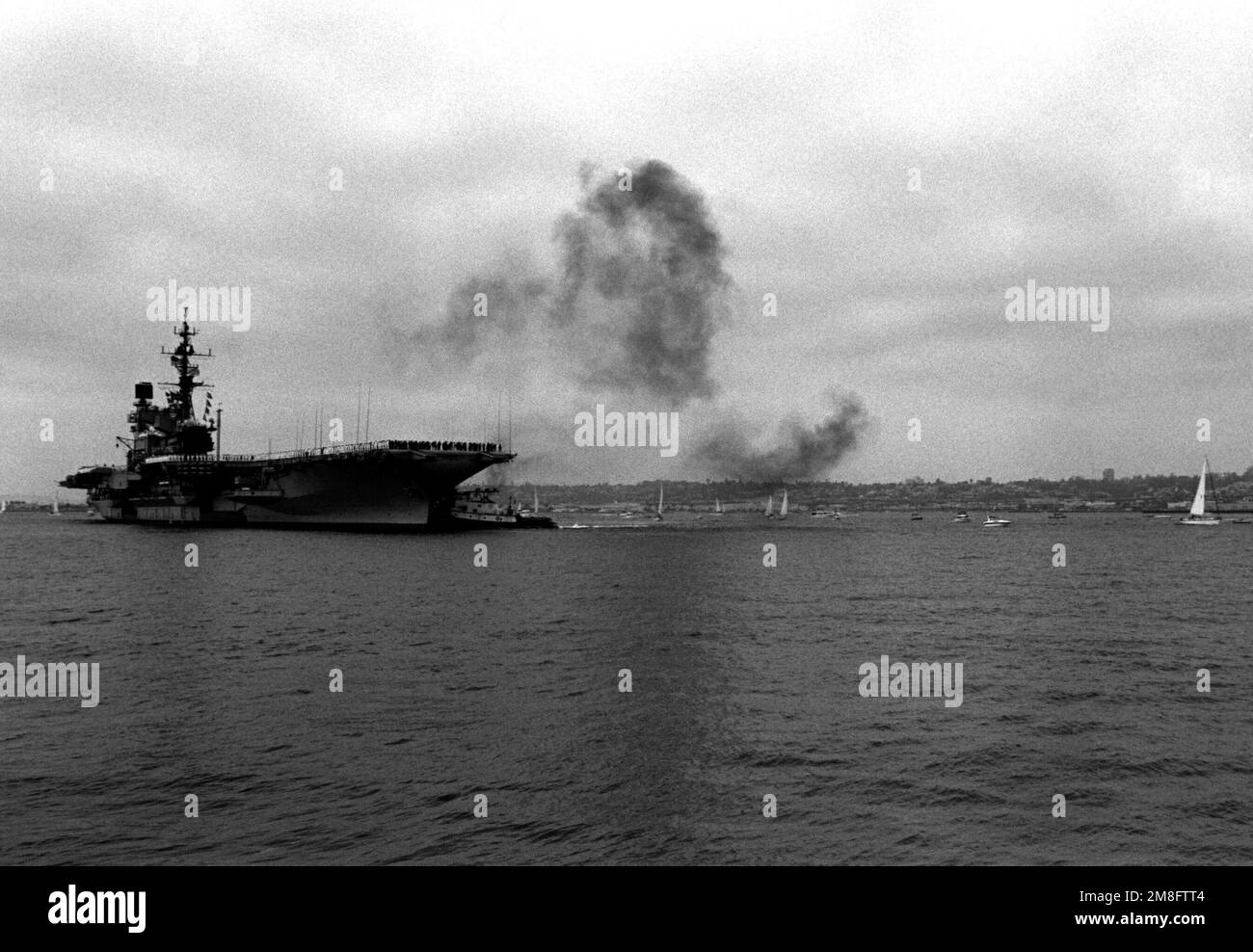 A tug boat helps maneuver the aircraft carrier USS MIDWAY (CV 41 ...