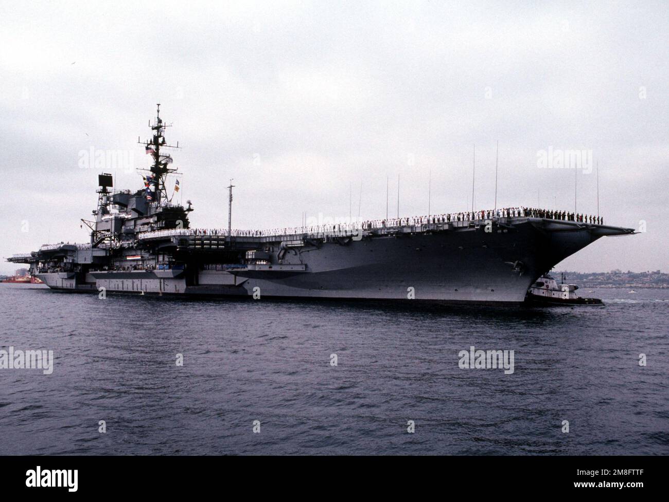 Crew members man the rails aboard the aircraft carrier USS MIDWAY (CV ...