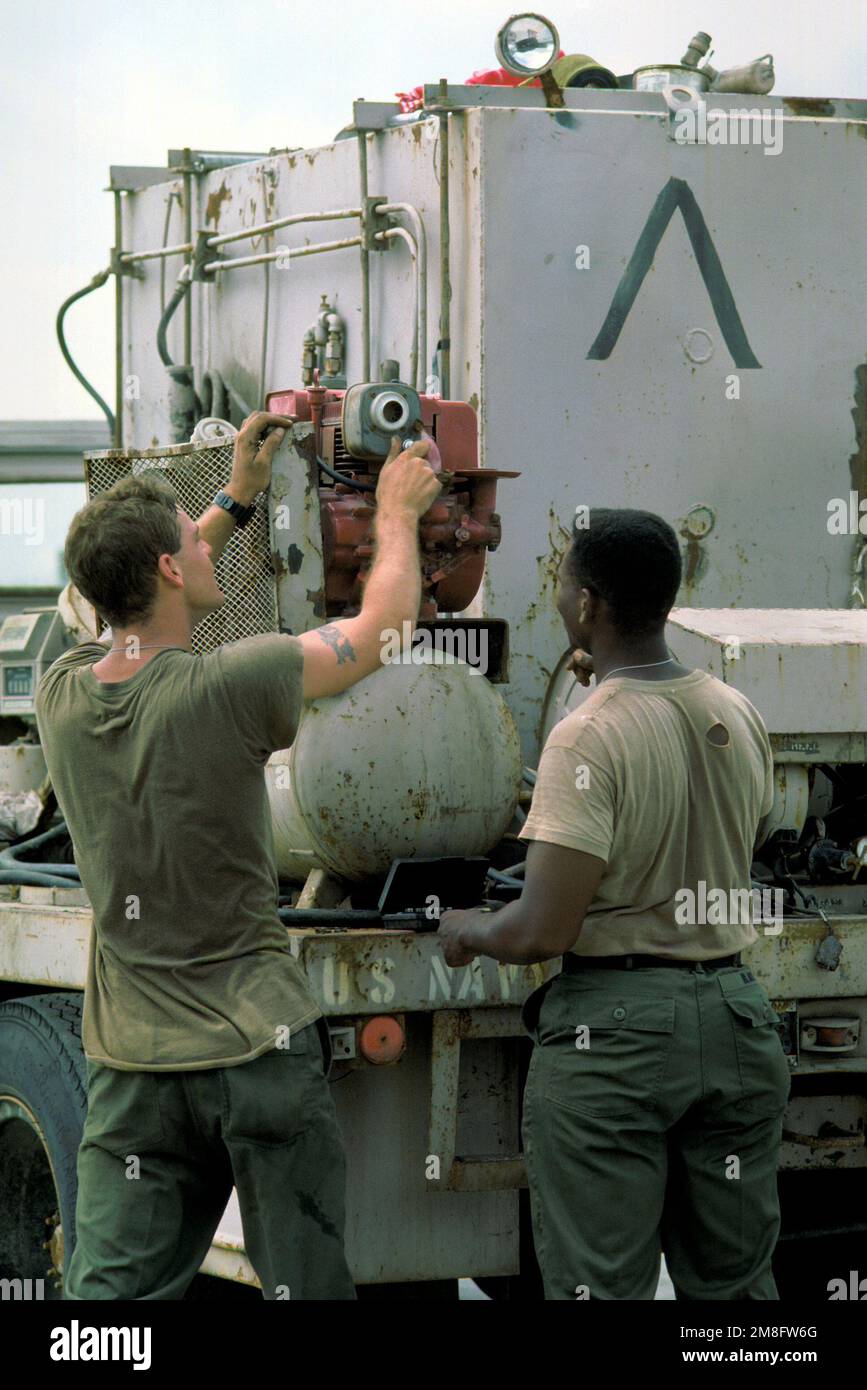 Two Seabees from Naval Mobile Construction Battalion 4 (NMCB-4) repair ...