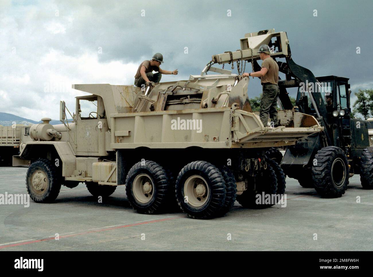 Two Seabees from Naval Mobile Construction Battalion 4 (NMCB-4) guide a ...
