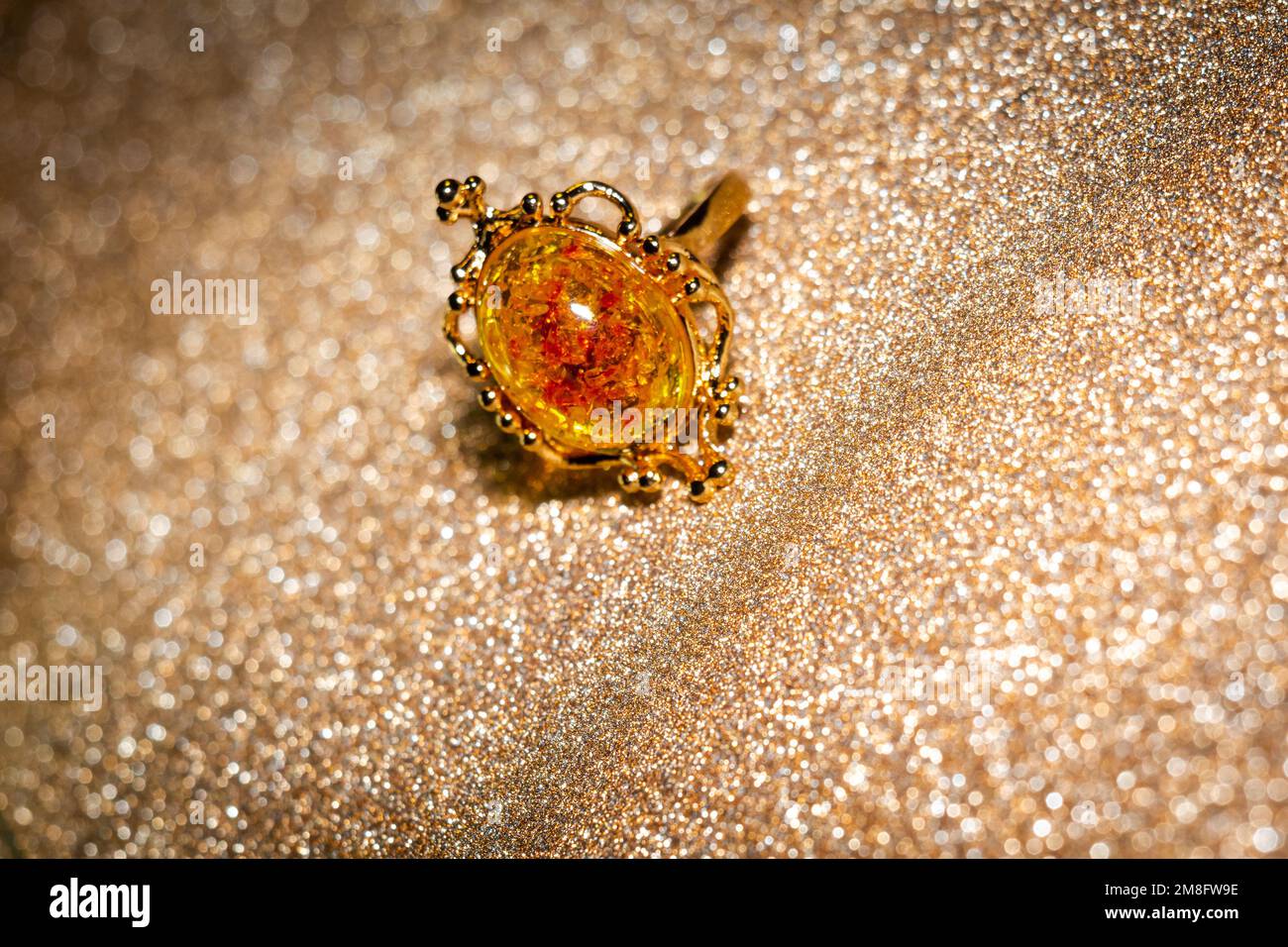 Fashion golden ring with big yellow amber, fake stone Stock Photo - Alamy