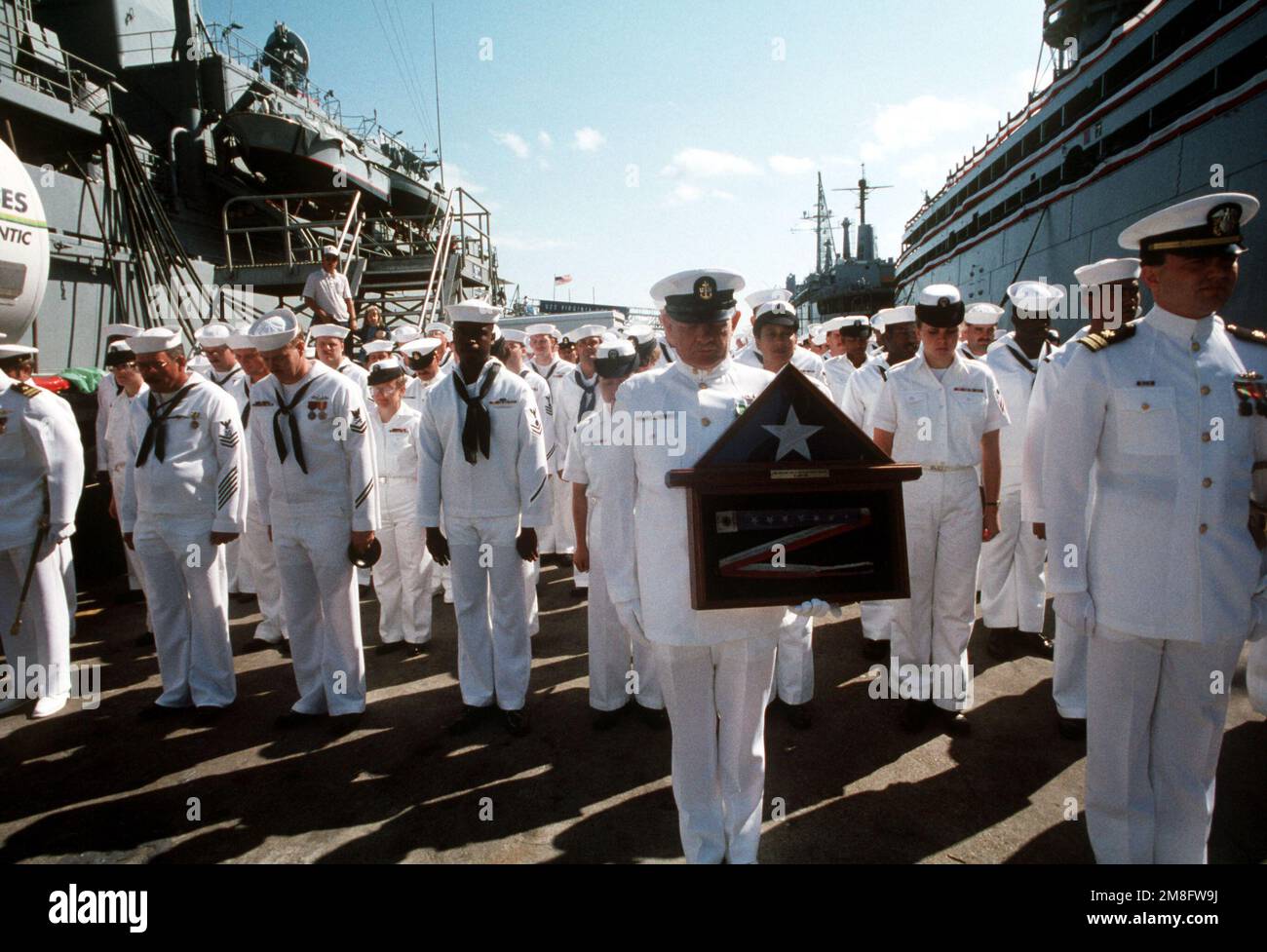 Crew members of the repair ship USS VULCAN (AR-5) bow their heads ...