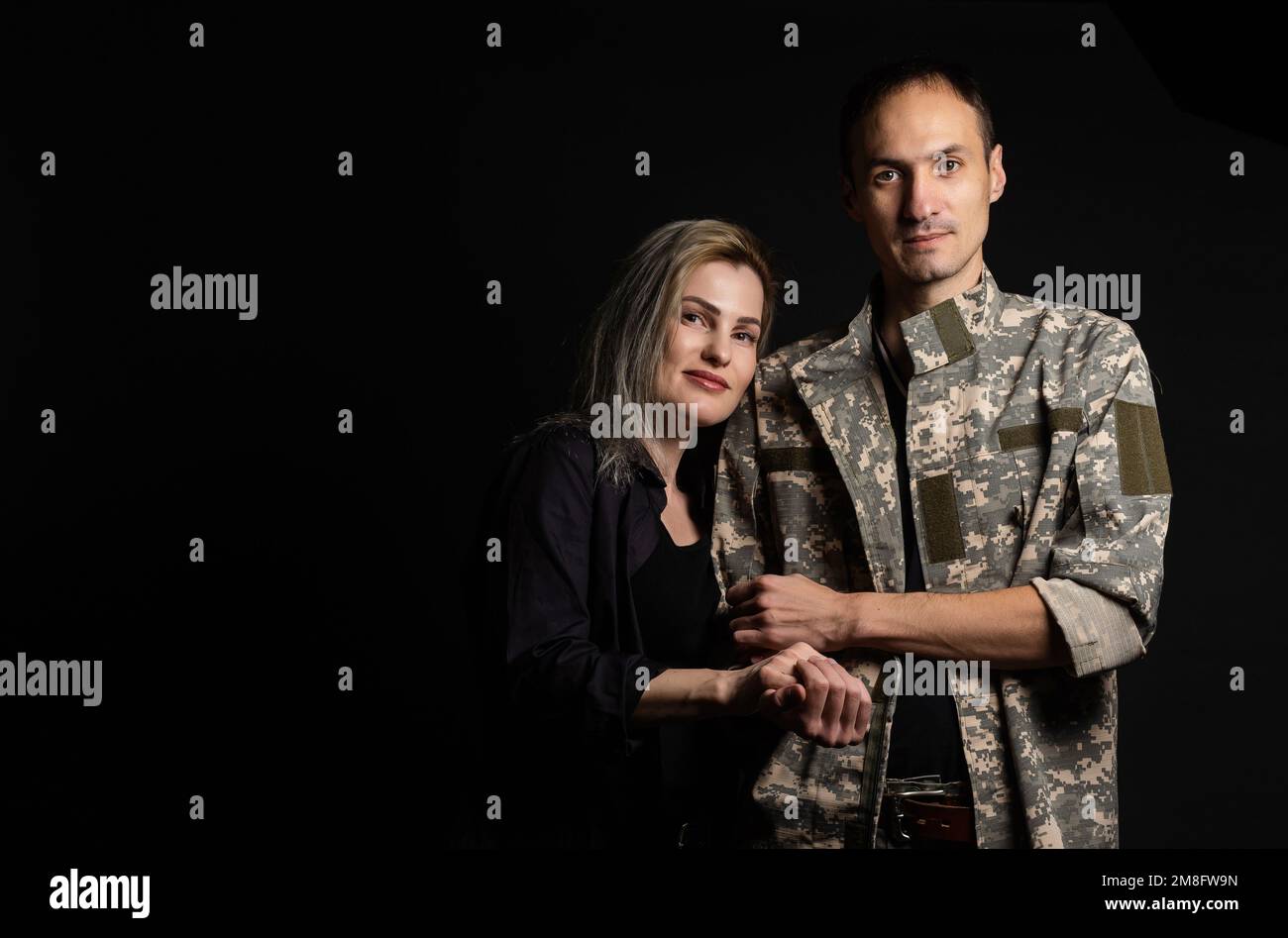 Happy woman hugging his husband came back from army. Smiling cheerful ...