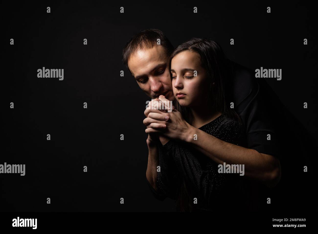 Young father and daughter praying with hands together with hope ...