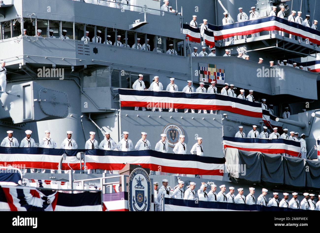 Crew members stand at parade rest aboard the battleship USS WISCONSIN ...