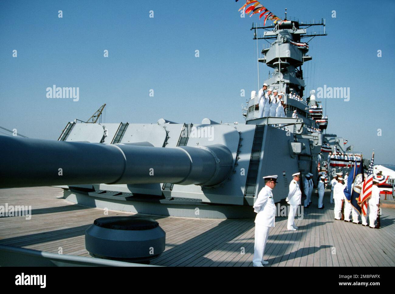 Crewmen stand at parade rest on one of the Mark 7 16-inch/50-caliber ...