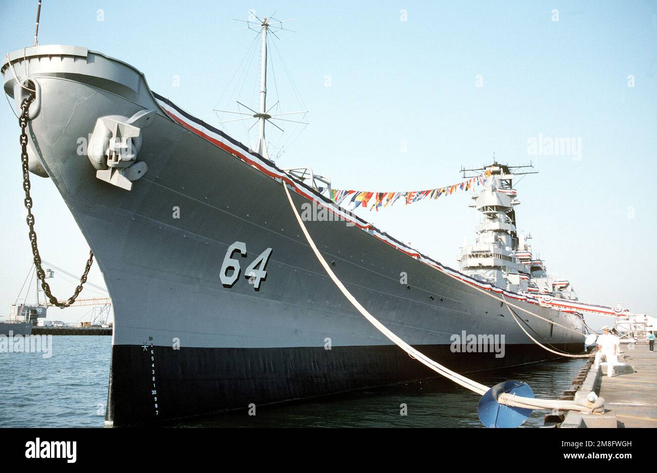 The battleship USS WISCONSIN (BB-64) stands moored to a pier in ...