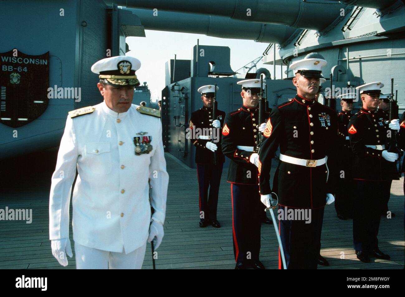 Members of the ship's Marine detachment stand at present arms as ADM ...