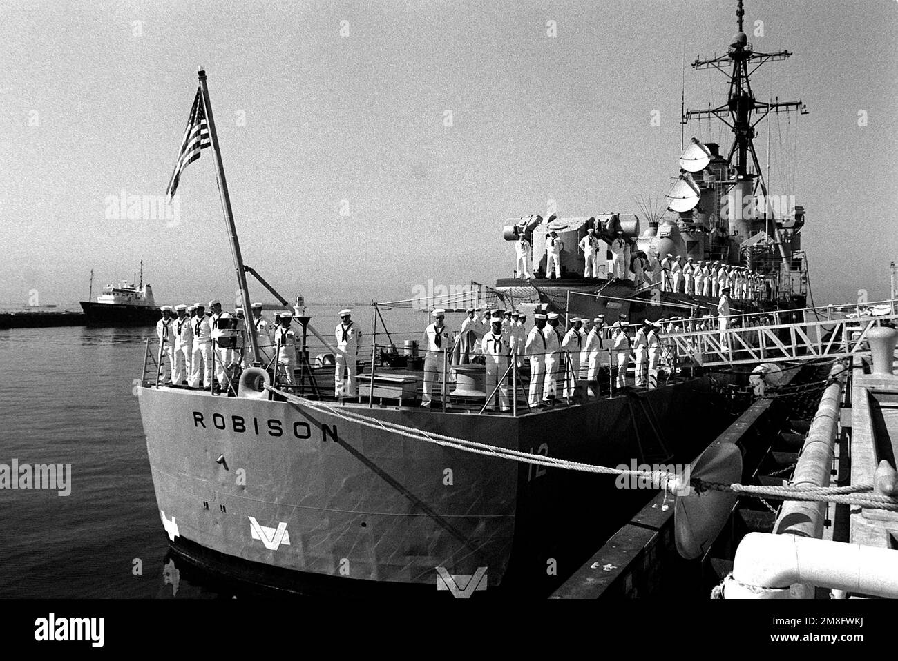 Crew members man the rails of the guided missile destroyer USS ROBISON ...