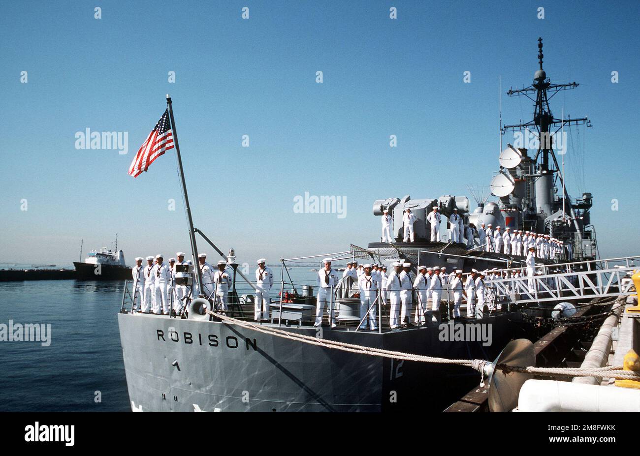 Crew members man the rails aboard the guided missile destroyer USS ...