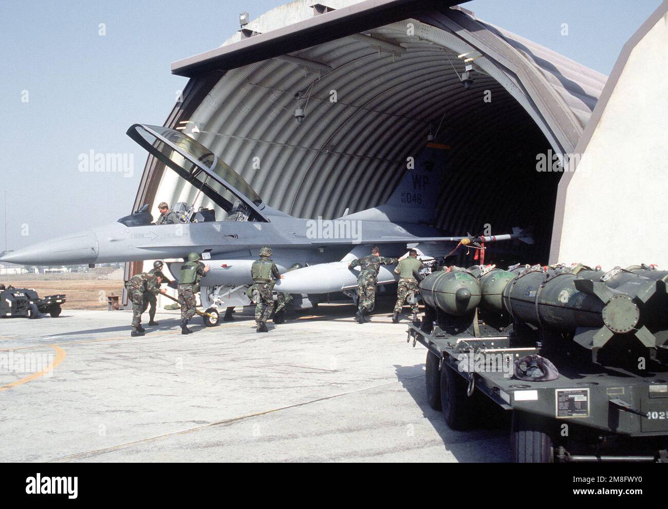 Ground defense forces assist in maneuvering an F-16D Fighting Falcon ...