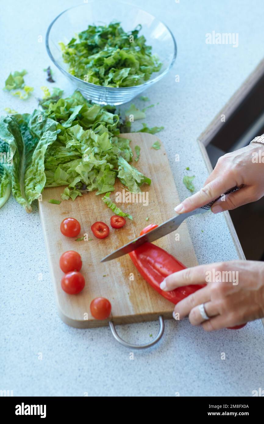Creating a healthy meal. View of vegetables being chopped on a cutting ...
