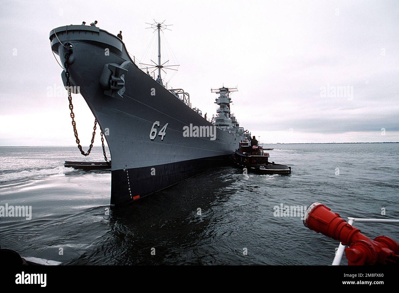 Commercial harbor tugs maneuver the battleship WISCONSIN (BB 64) out to ...