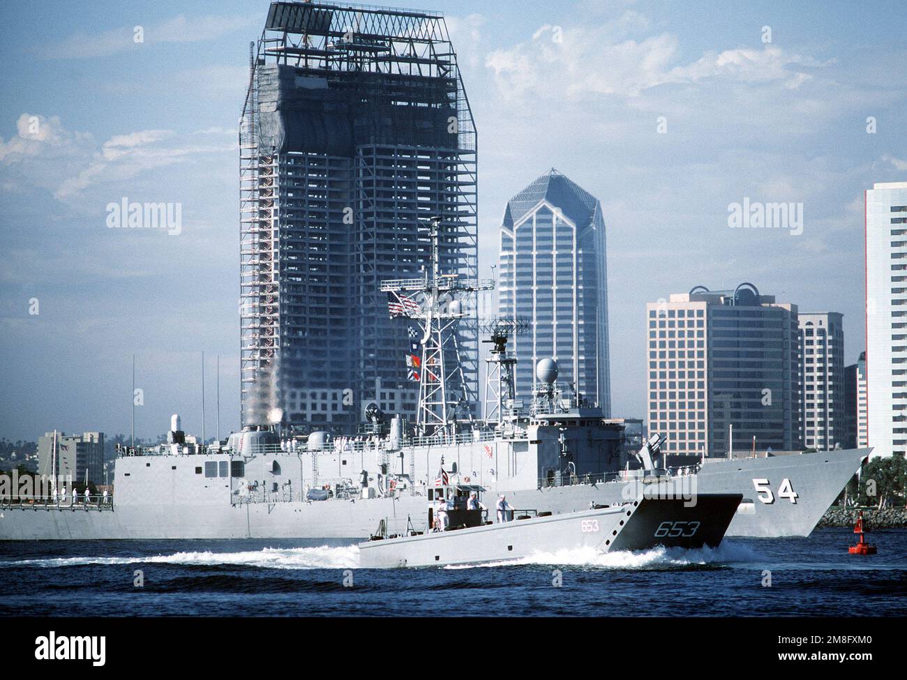An LCM-8 mechanized landing craft passes the guided missile frigate USS ...