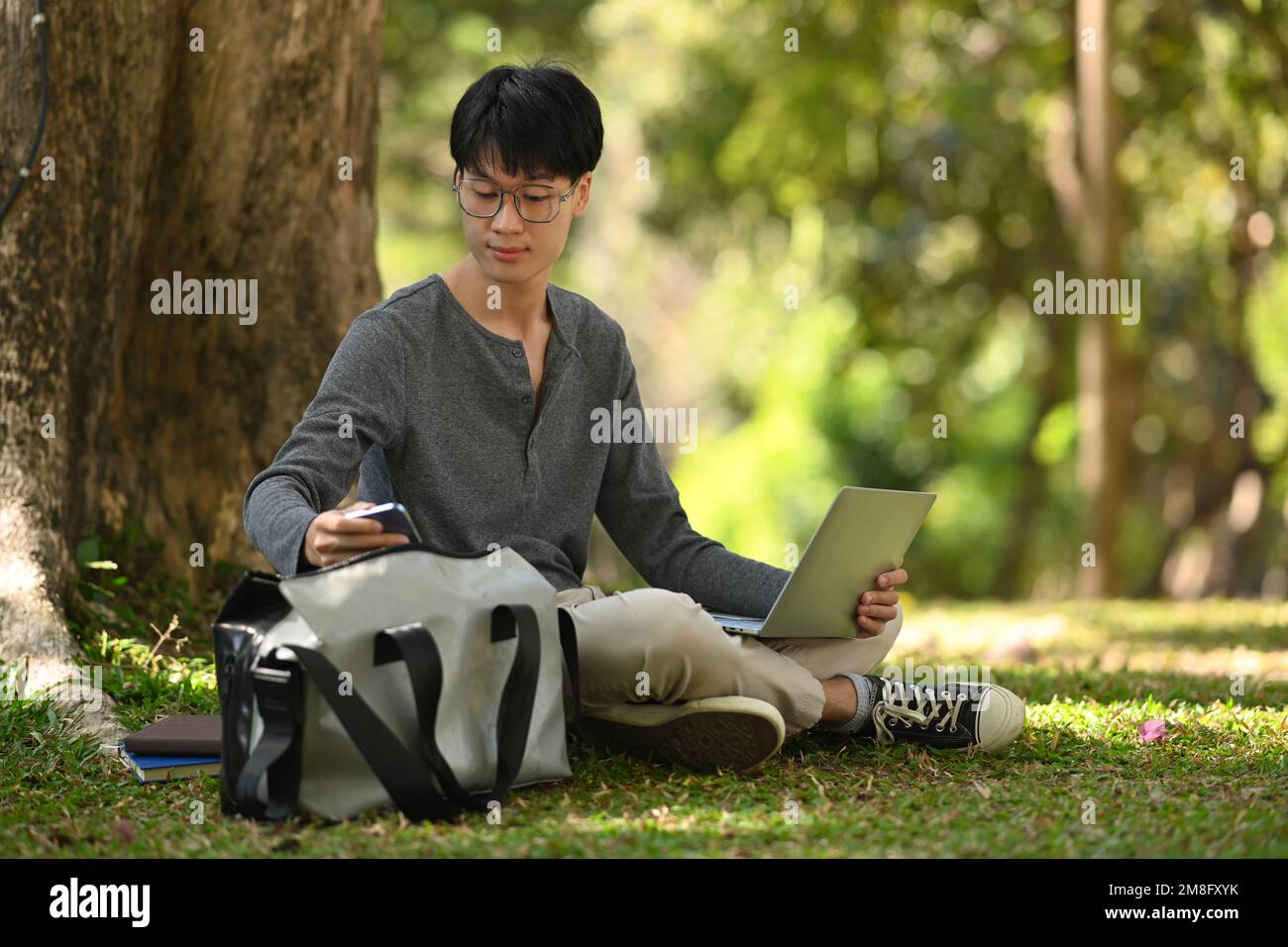 College student sitting under tree hi-res stock photography and images ...