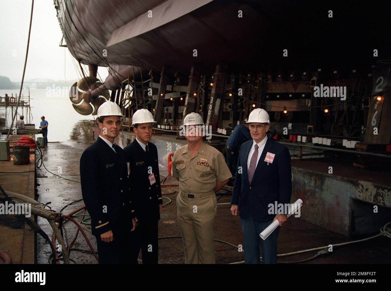 CMDR John M. Kelly, center, poses for a photograph with, from left, ENS ...