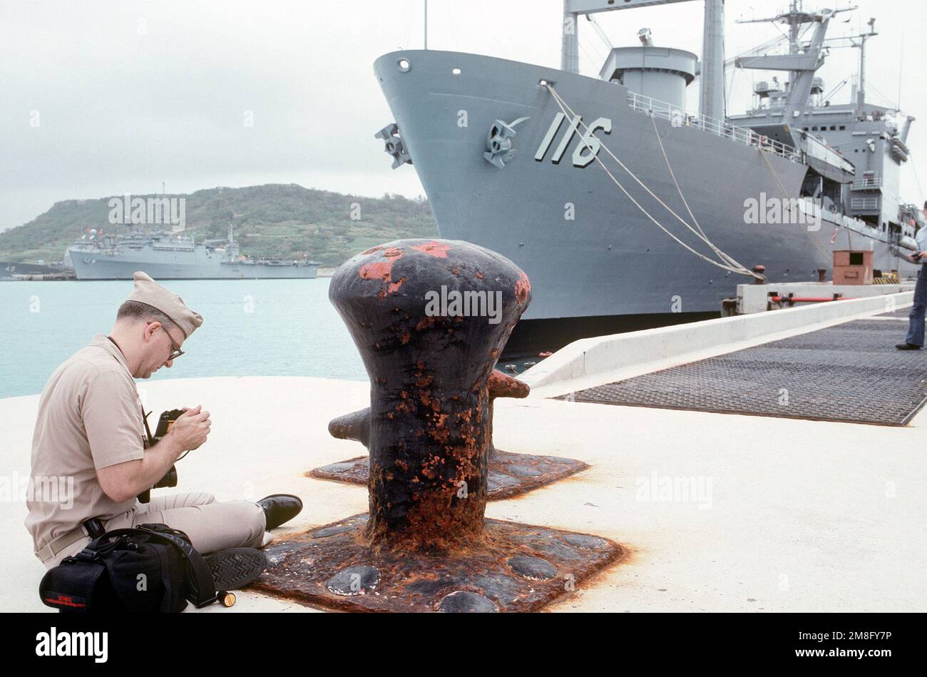 ENS J. R. Hilton prepares to photograph the amphibious cargo ship USS ...