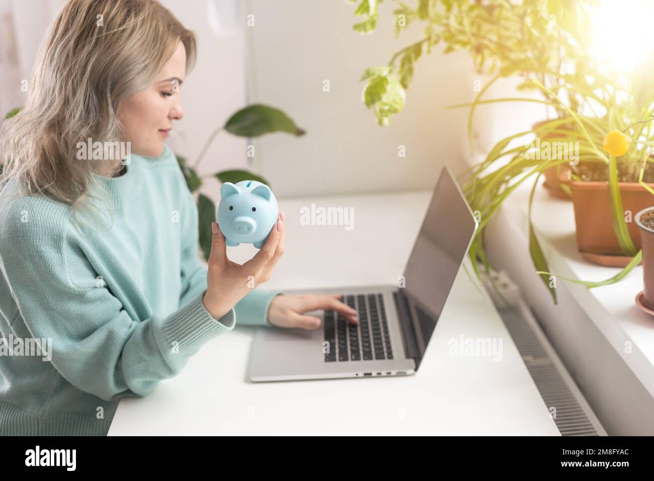 Young woman planning save salary money early years using laptop ...