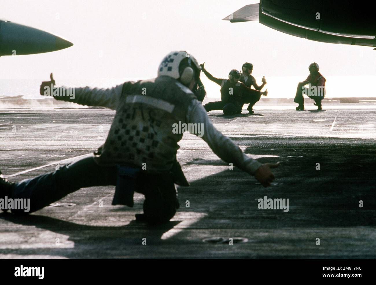 Two final checkers signal that an F-14B Tomcat aircraft is ready for ...