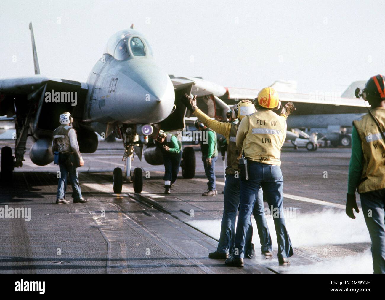 A catapult crewman guides a Fighter Squadron 143 (VF-143) F-14B Tomcat ...