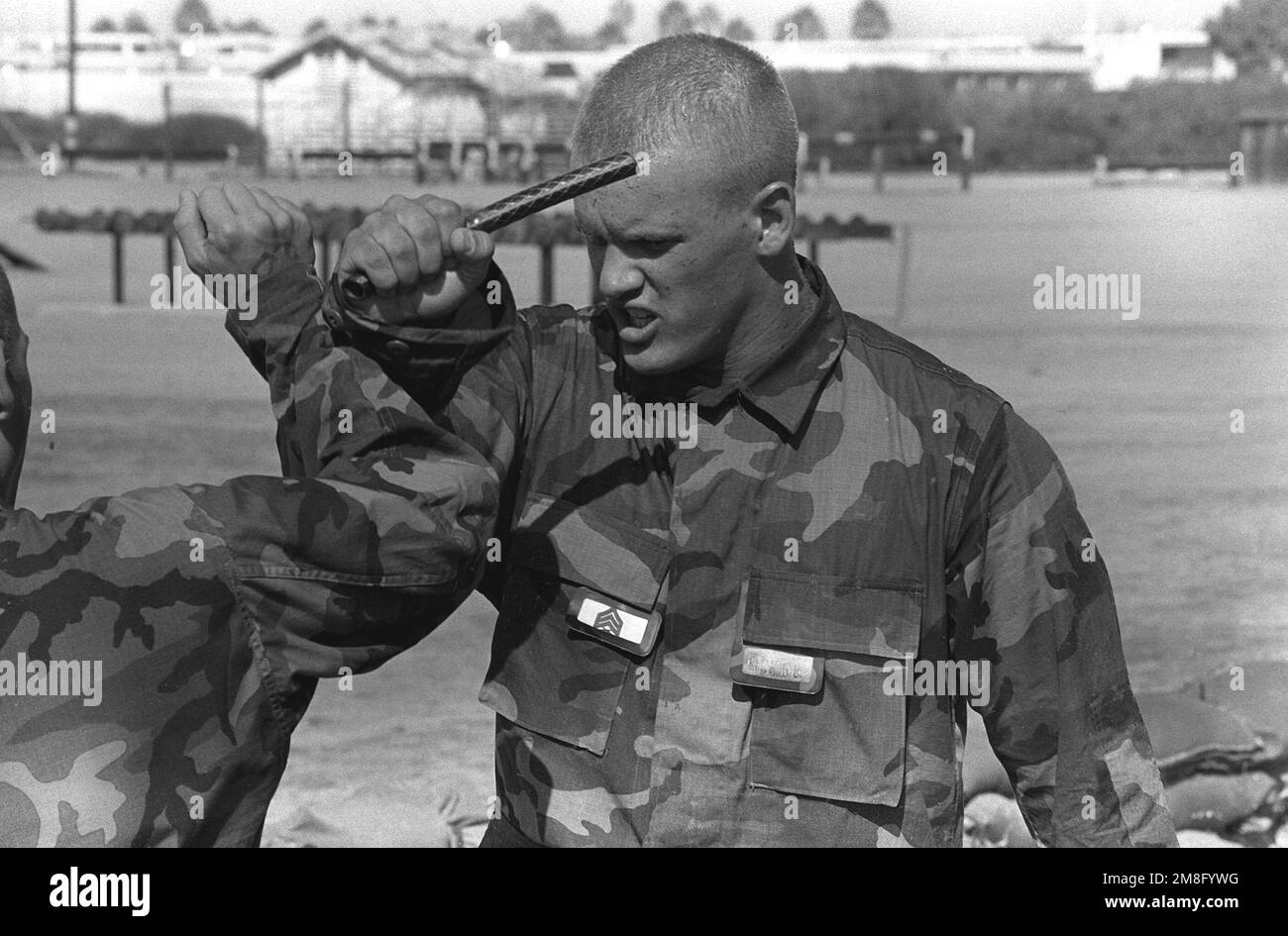 Two Marine recruits, one using a short piece of rubber hose as a ...