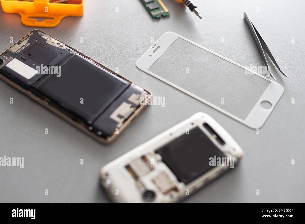 Technician repairing inside of mobile phone by soldering iron. the ...
