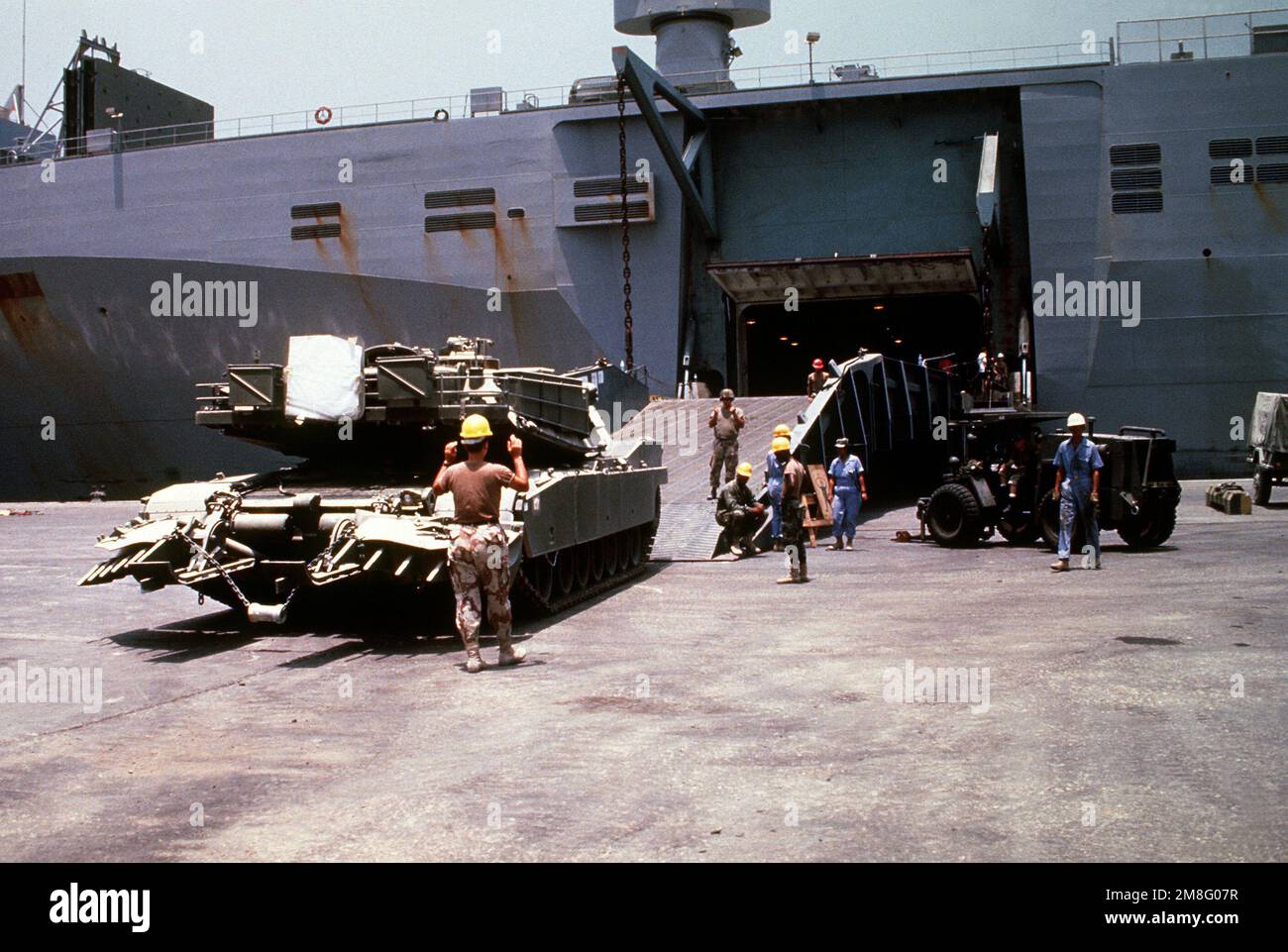 Soldiers coordinate the loading of an M-1A1 Abrams main battle tank ...