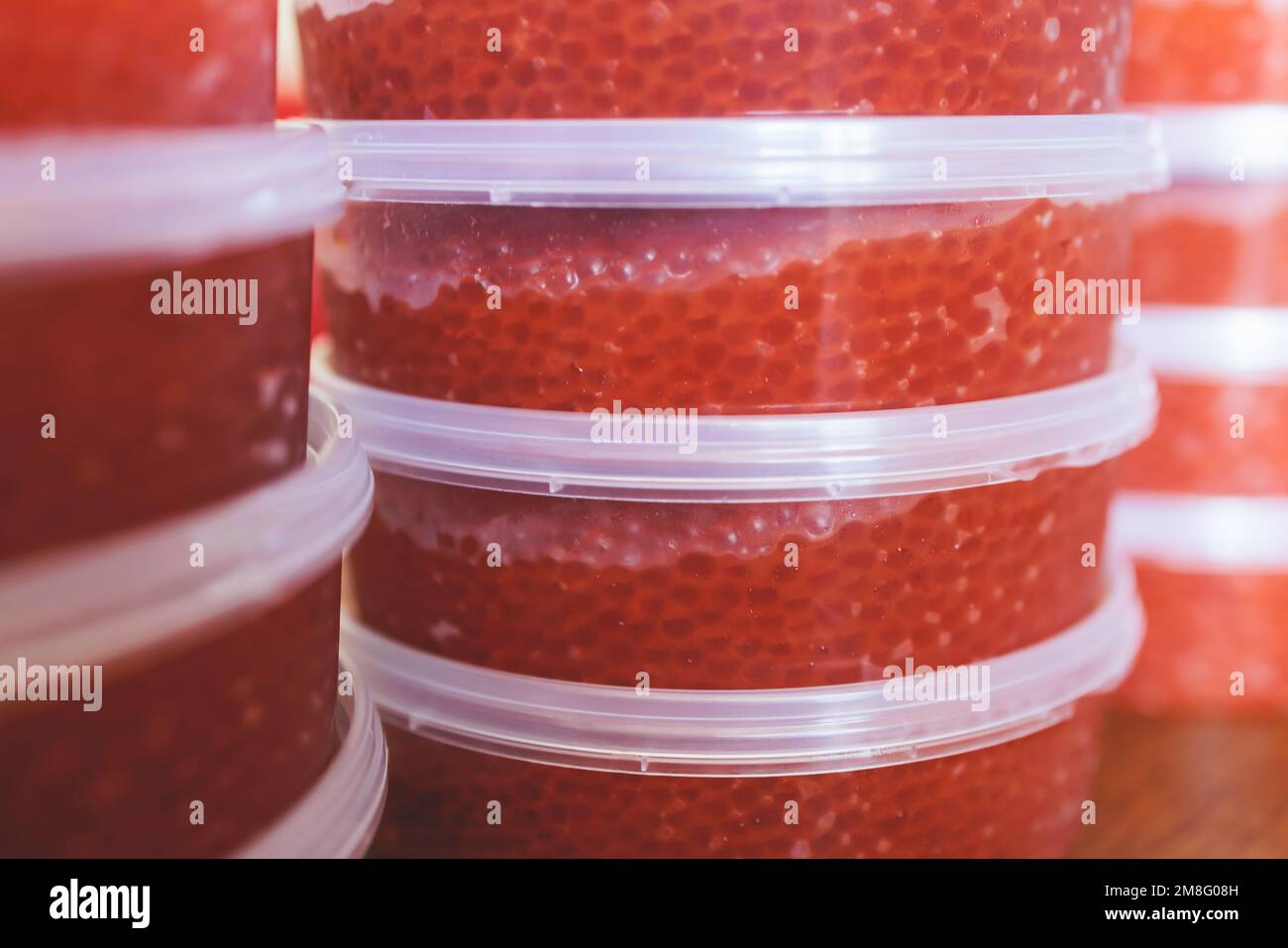 Red caviar plactic jars, rows of salted canned red caviar containers ...