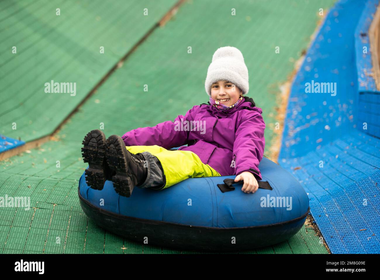 a little kid enjoying tubing down the wavy track ski resort Stock Photo ...