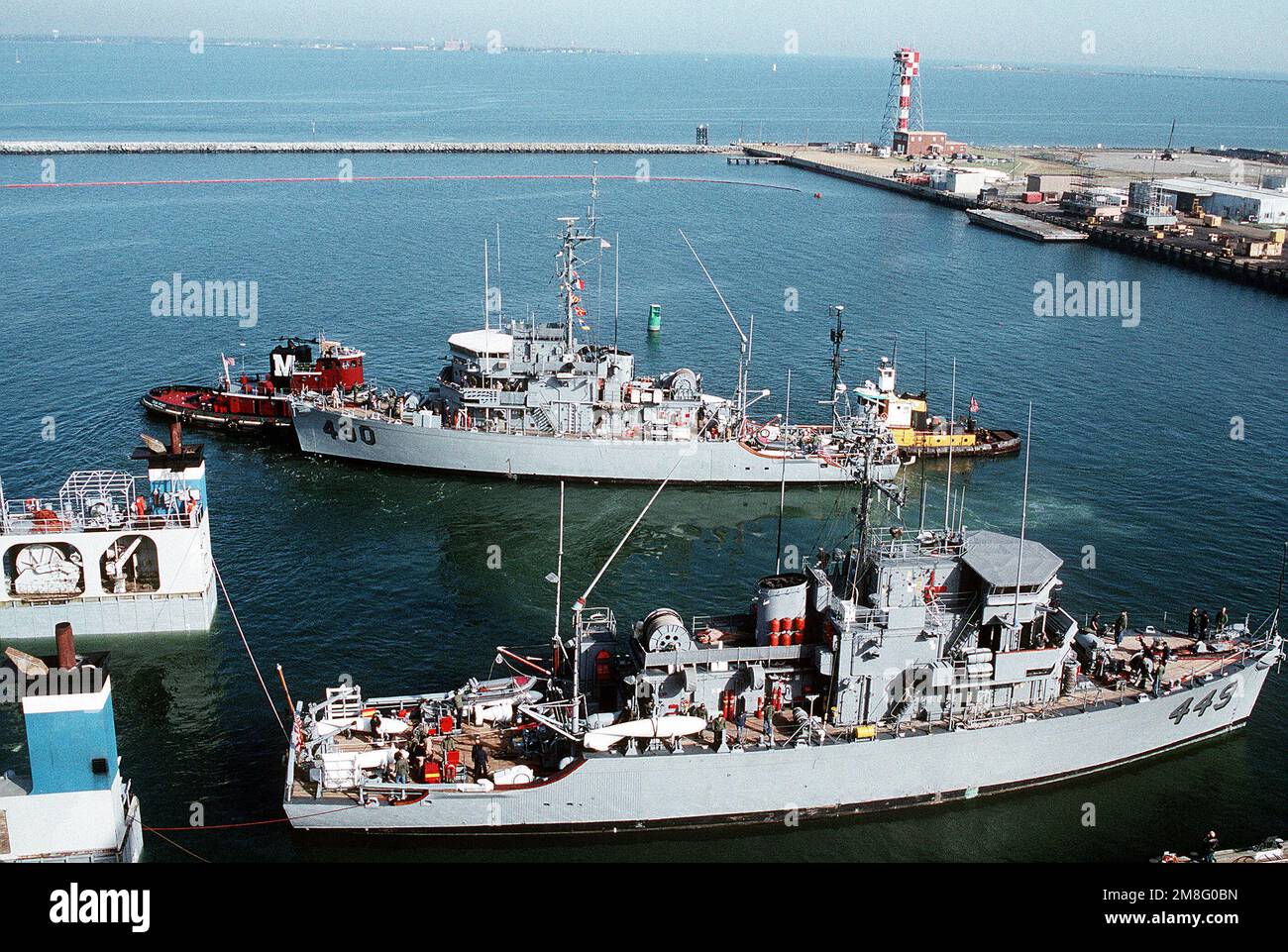 Tug boats move the ocean minesweeper USS LEADER (MSO-490) clear of the ...