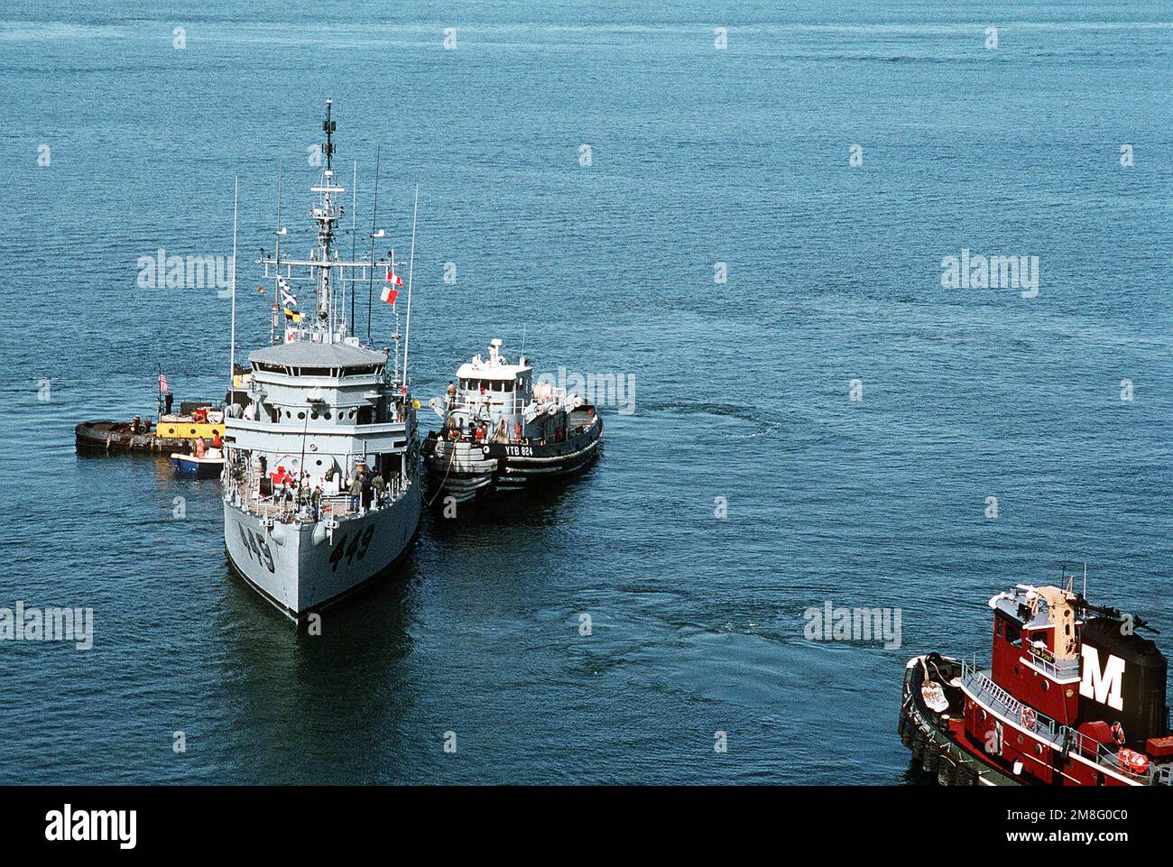 The ocean minesweeper USS IMPERVIOUS (MSO-449) is moved to the pier by ...