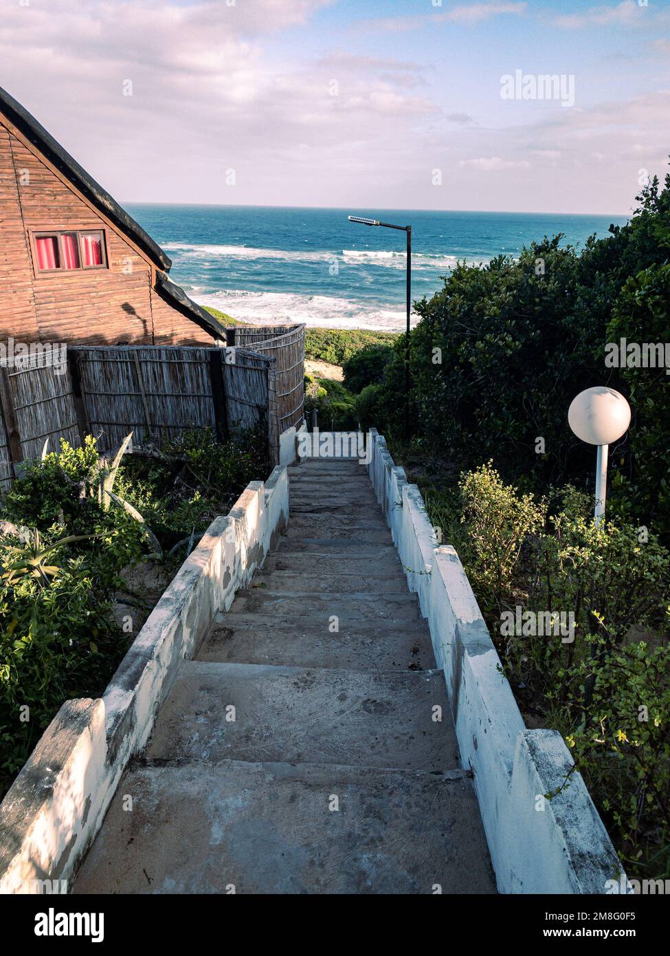 A vertical shot of narrow stone stairs to the sea on a sunny day Stock ...