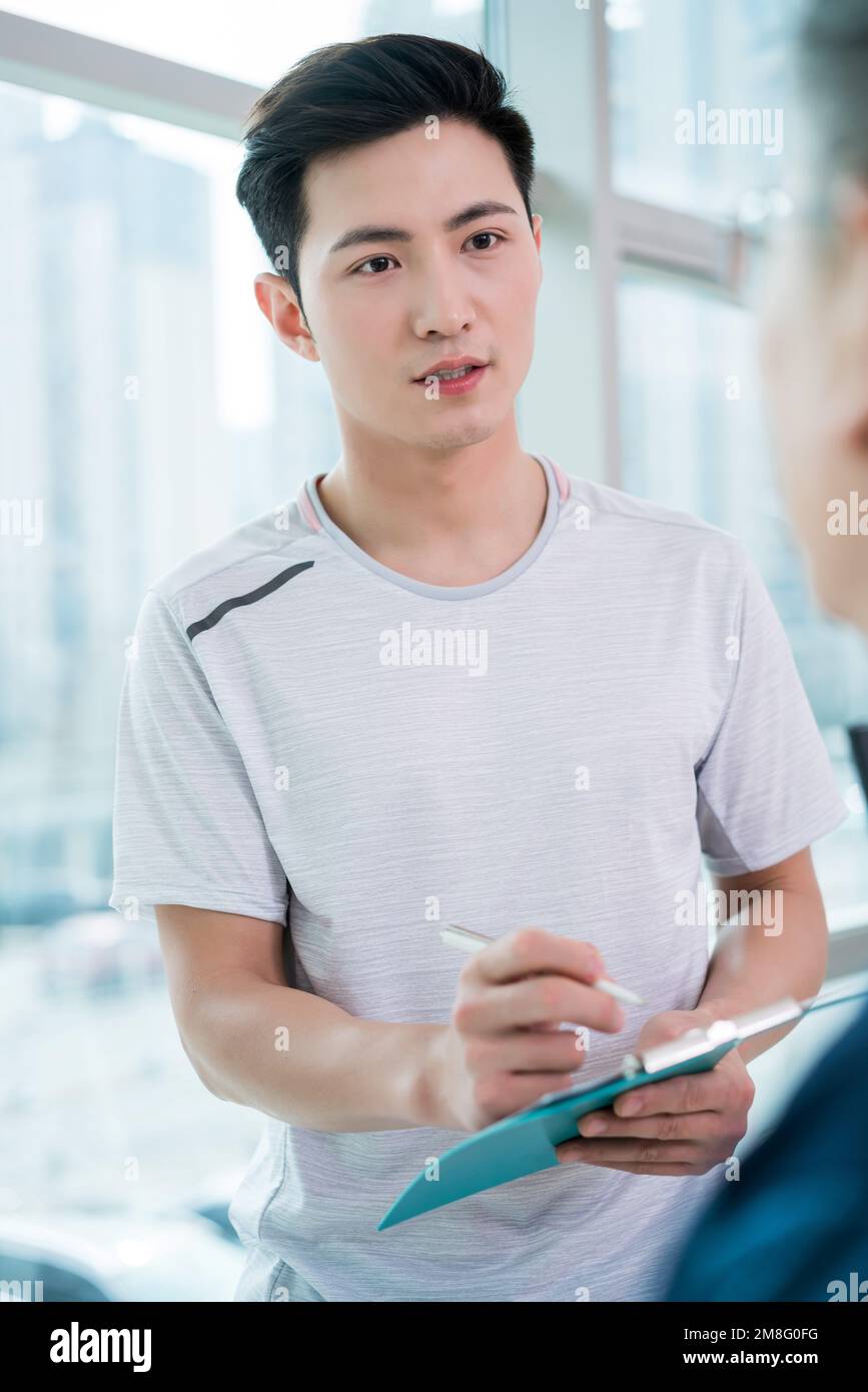 Under the guidance of the elderly man in personal training in the gym ...