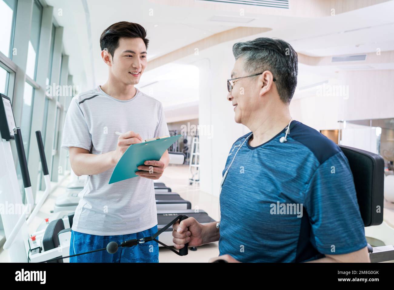 Under the guidance of the elderly man in personal training in the gym ...