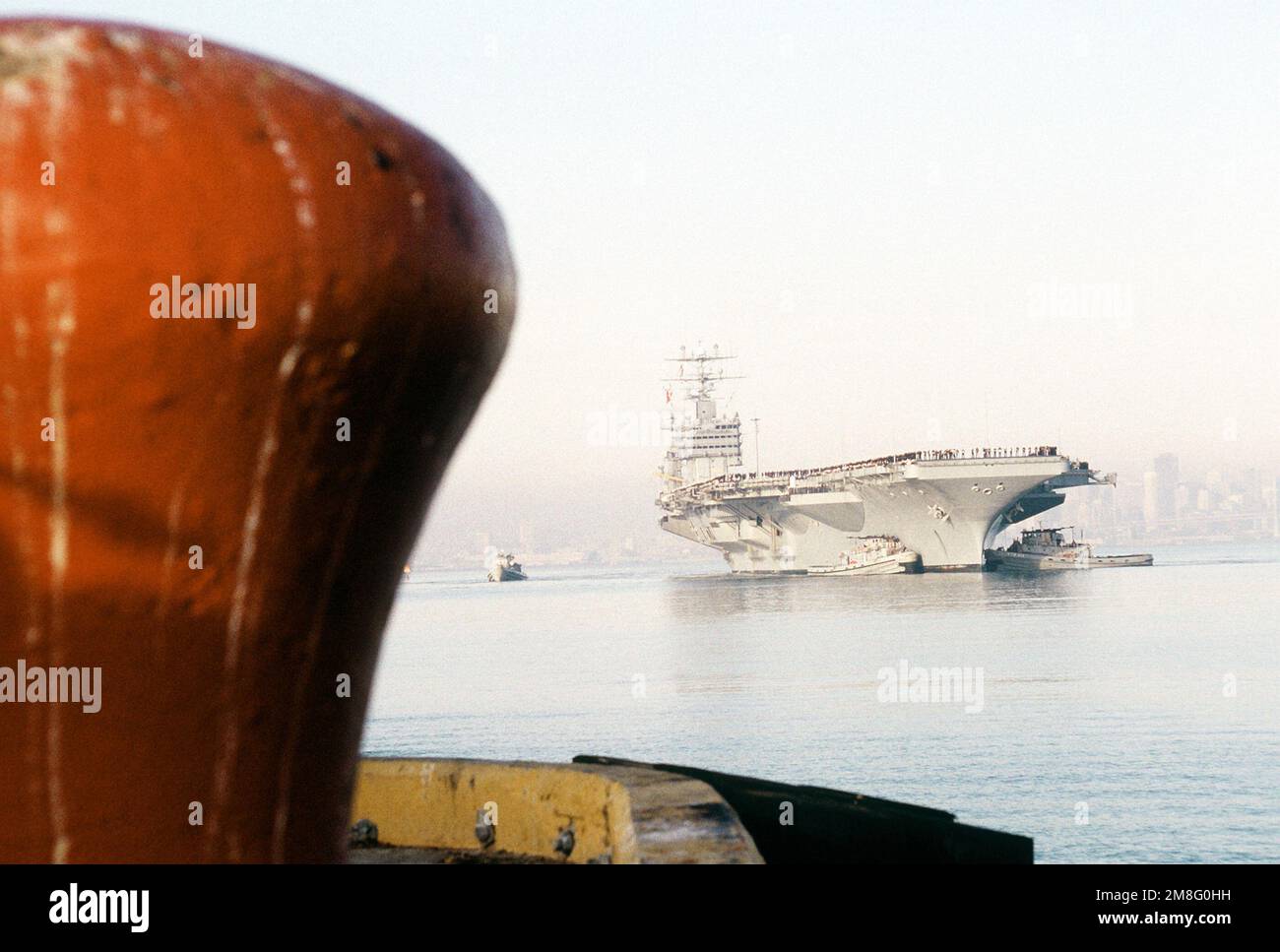 Crew members man the rails aboard the nuclear-powered aircraft carrier ...