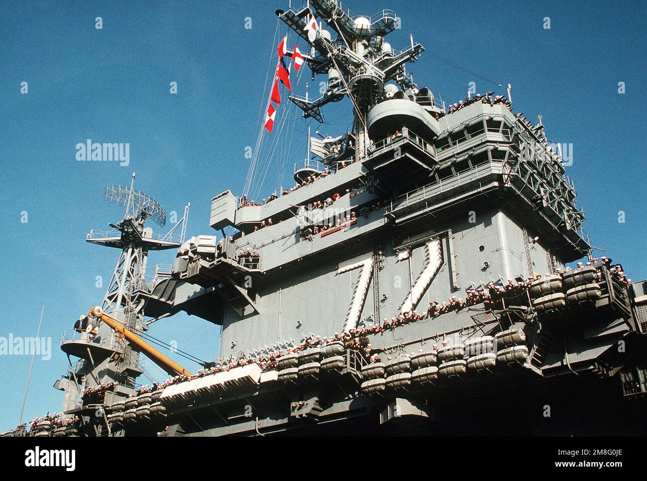 Crew members man the rails on the flight deck and island of the nuclear ...