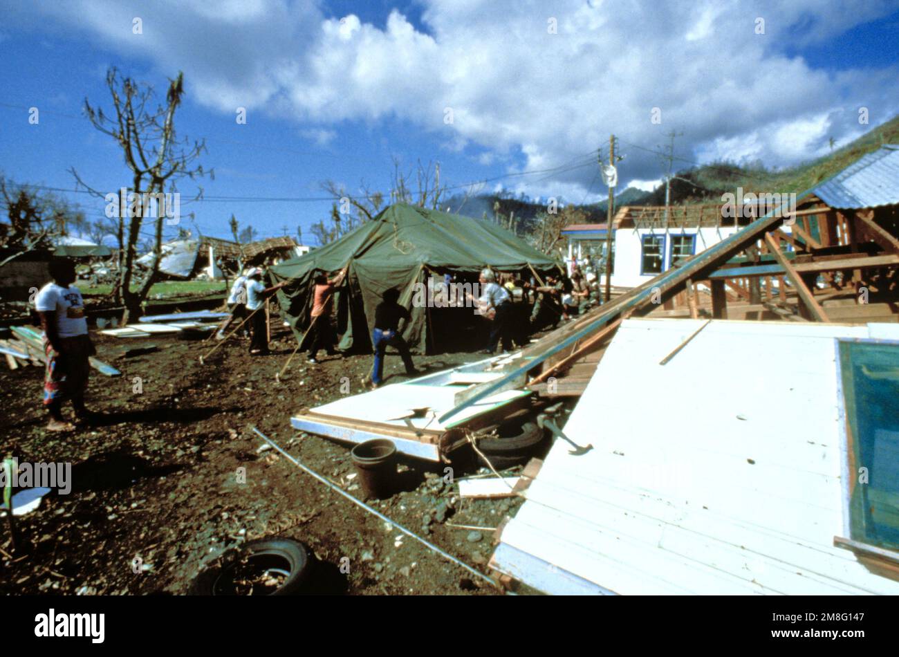 A tent is erected amid the houses and debris, destroyed by Cyclone Val ...