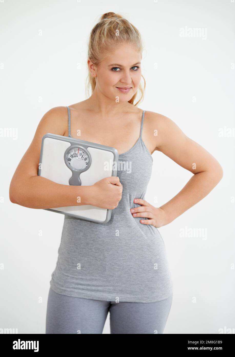 Daily weigh-ins help her keep those diet goals. Attractive young woman ...