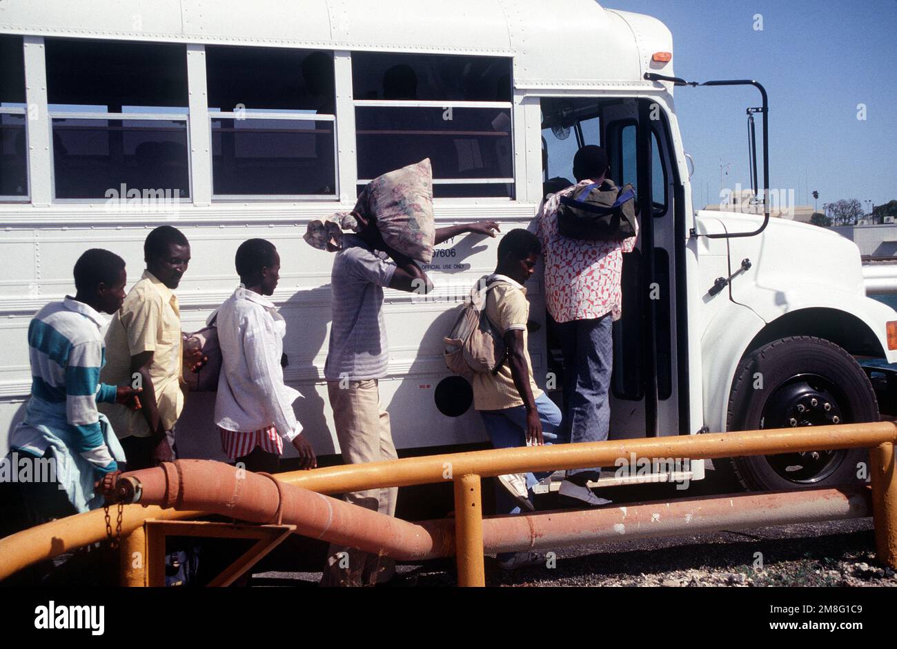 Refugees board a bus that will transport them to Camp McCalla, site of ...
