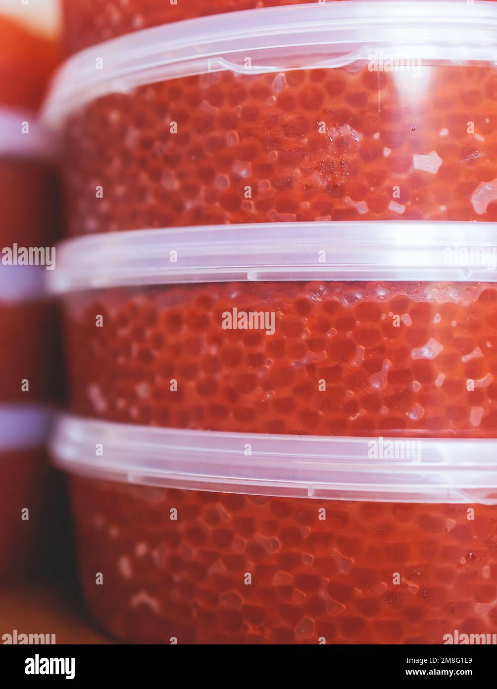 Red caviar plactic jars, rows of salted canned red caviar containers ...