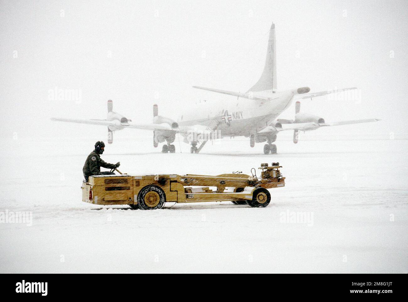 An aviation ordnanceman drives a weapon loader by a P-3 Orion anti ...