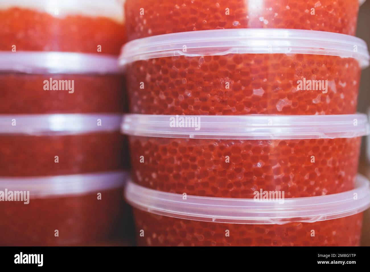 Red caviar plactic jars, rows of salted canned red caviar containers ...