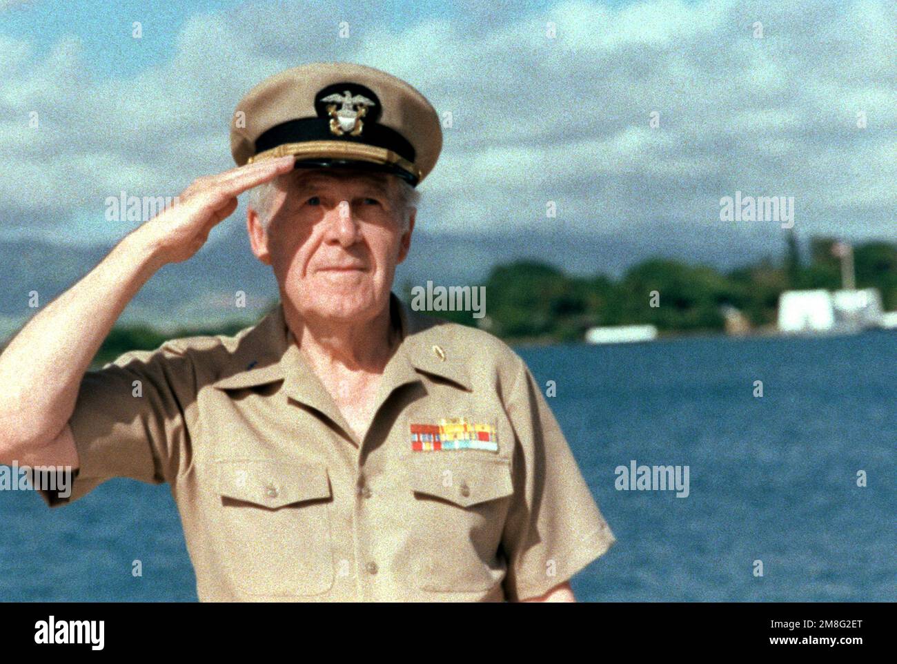 Retired CWO Robert J. Peth salutes during a ceremony marking the 50th ...