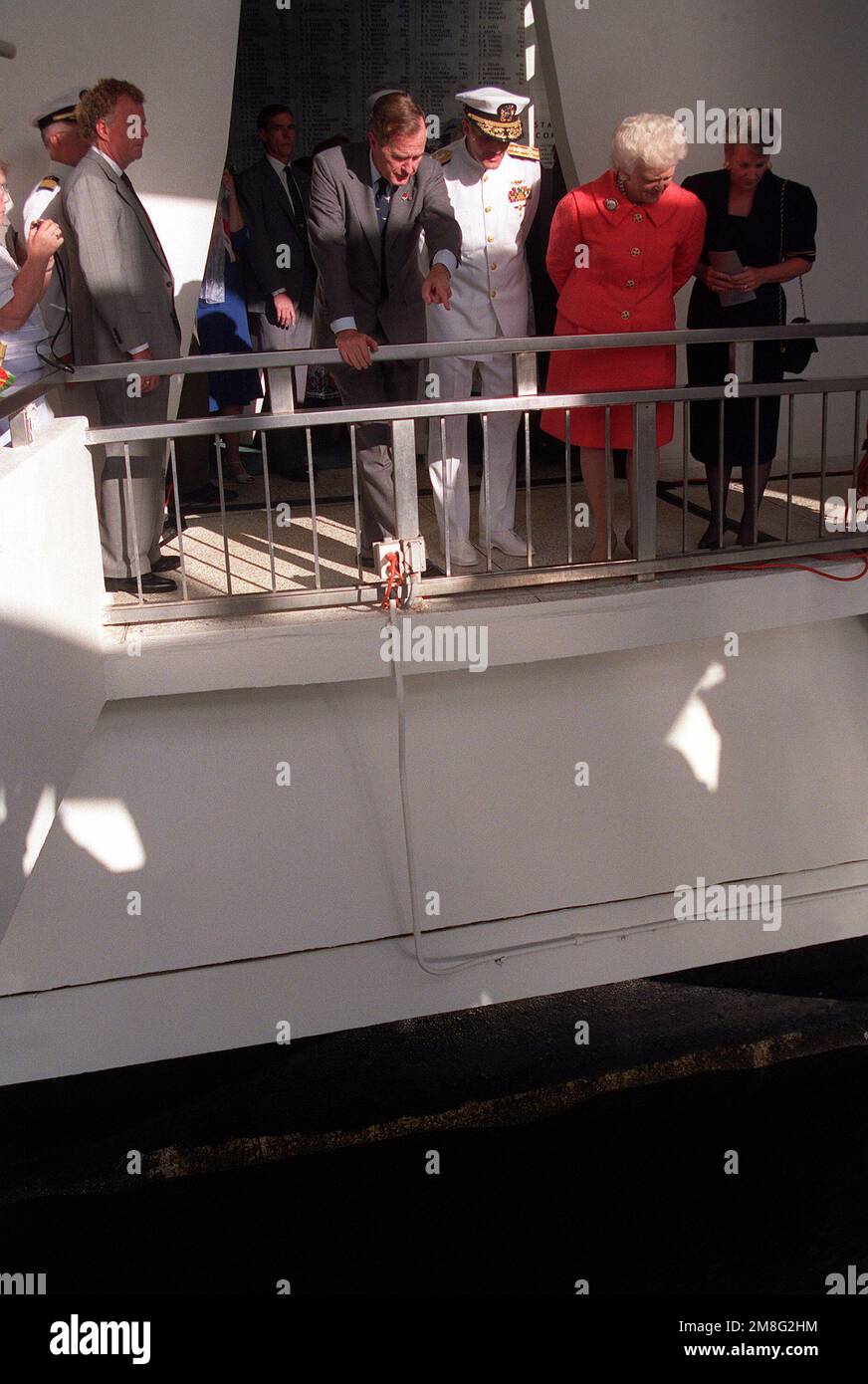 President George Bush points toward the sunken battleship USS ARIZONA ...