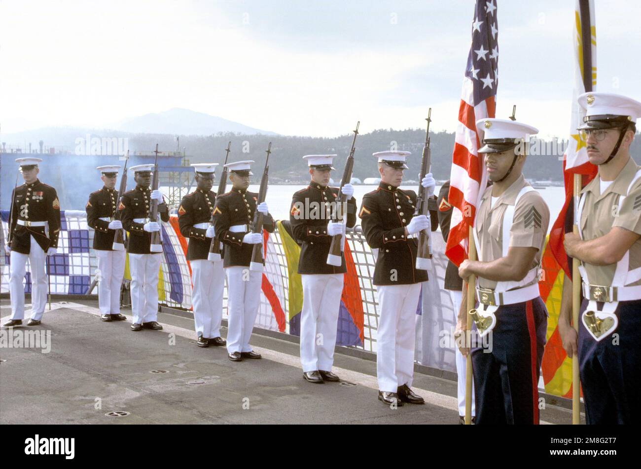 A Marine firing detail lines up along the rail behind the color guard ...